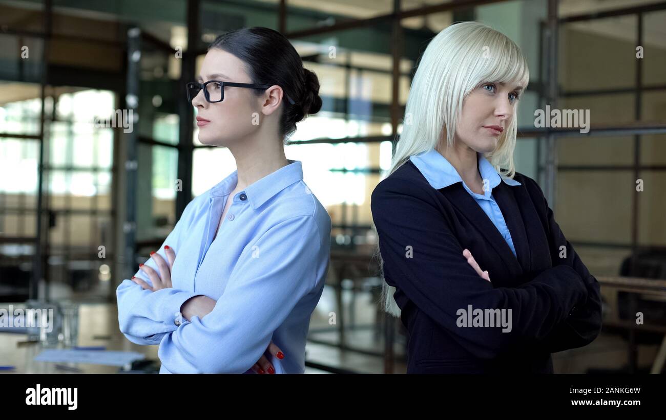 Two business women standing back to back looking angrily, career ...
