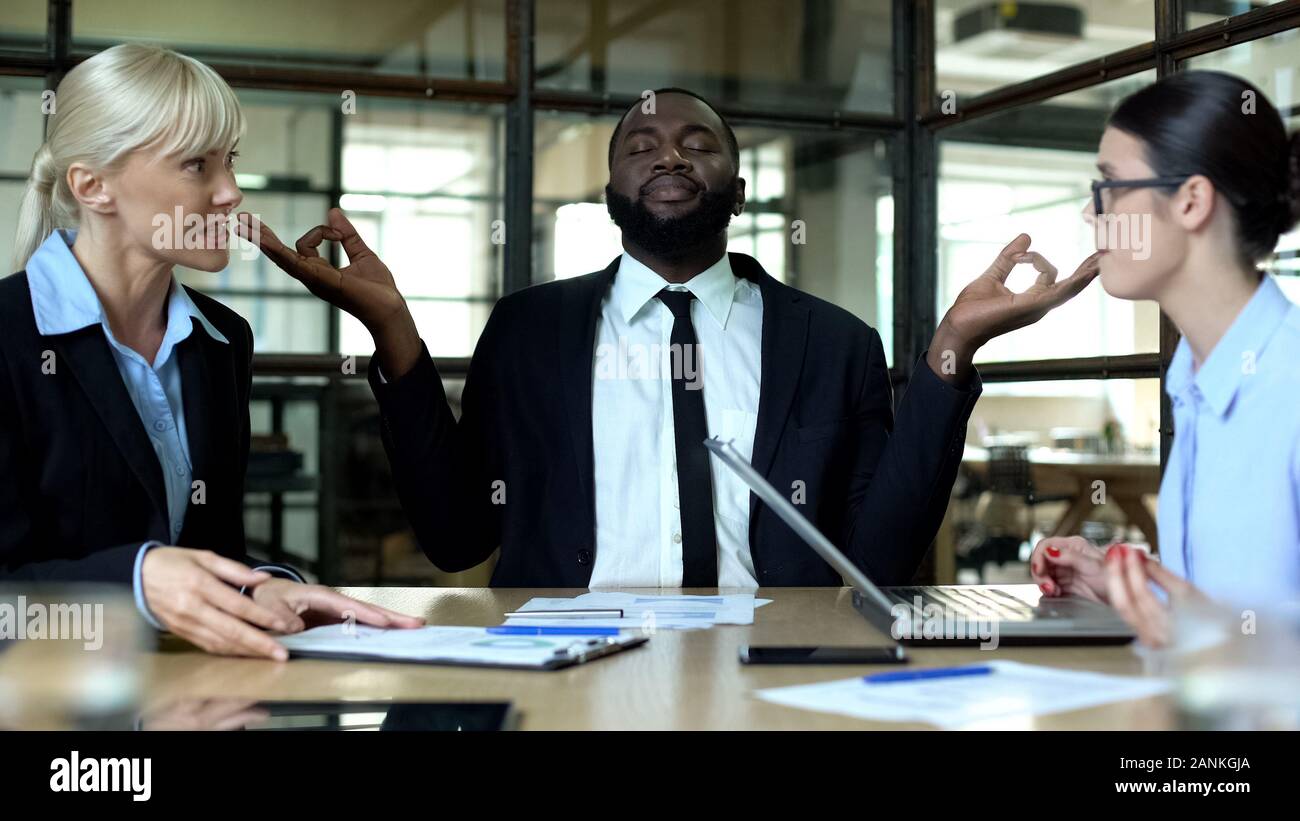 Businessman meditating in office, tired of female colleagues conflict ...