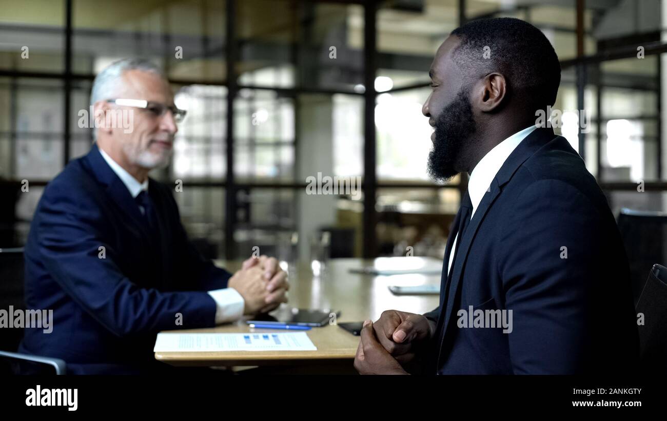 Happy black manager smiling at boss in office, successful business ...