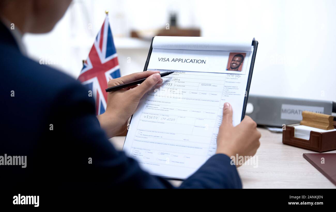 Female embassy worker checking visa application office, british flag ...