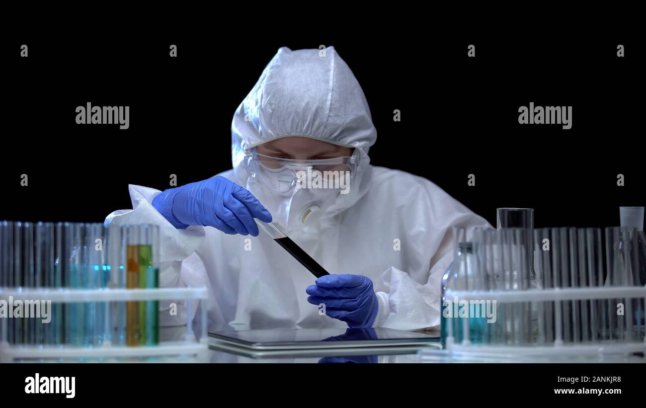 Laboratory scientist studying black liquid in tube, dangerous substance ...