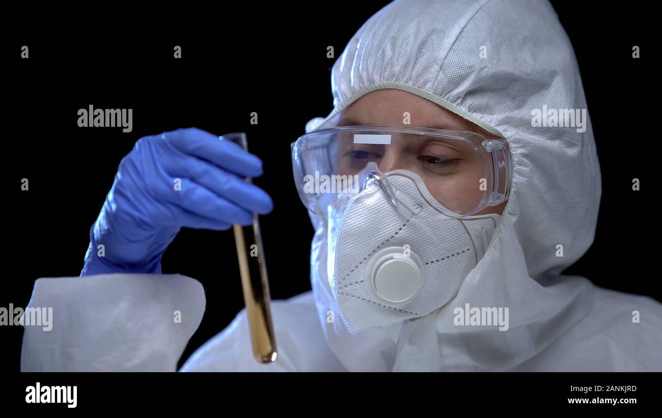 Lab assistant in protective suit studying sample of detergent, research ...