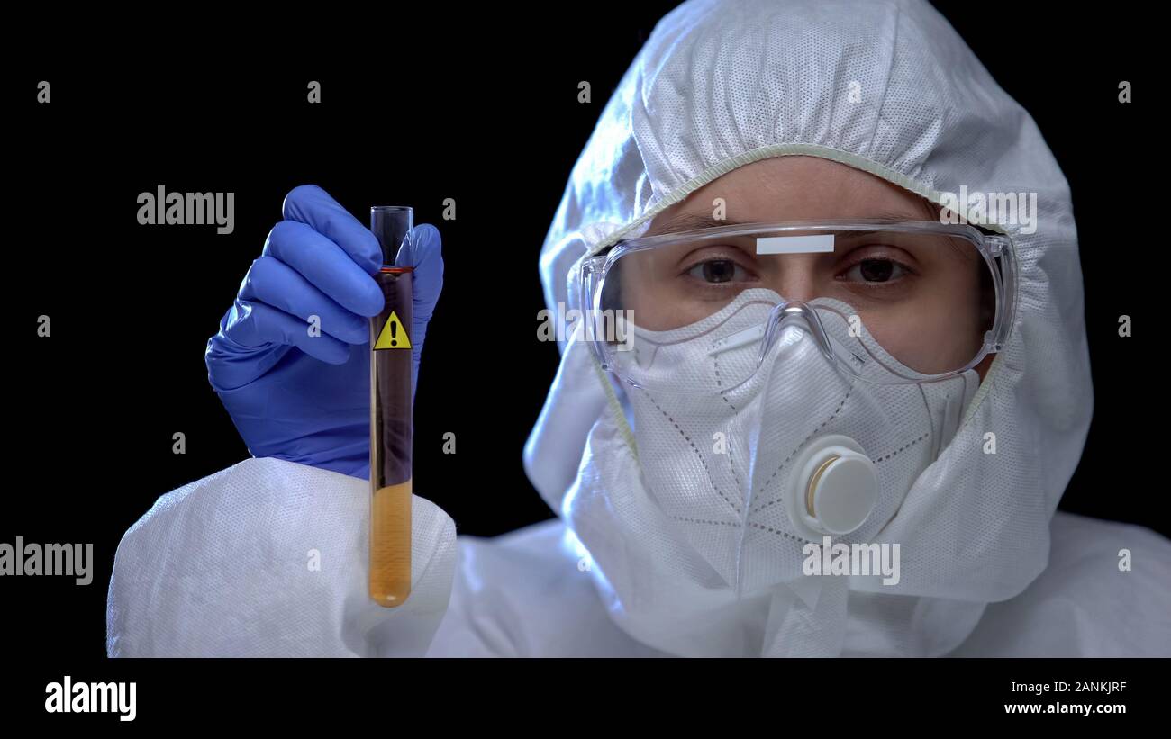 Female lab worker showing test tube with detergent, chemistry, caution ...
