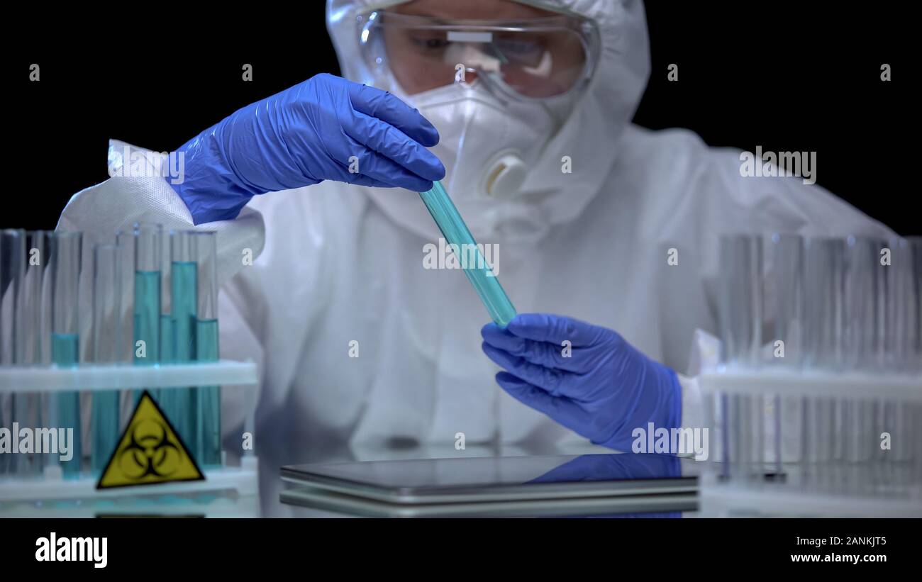 Female lab worker examining biohazard fluids in tubes, dangerous work ...