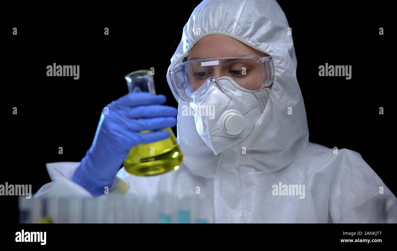 Worker of scientific lab analyzing flammable liquid in flask, toxic ...