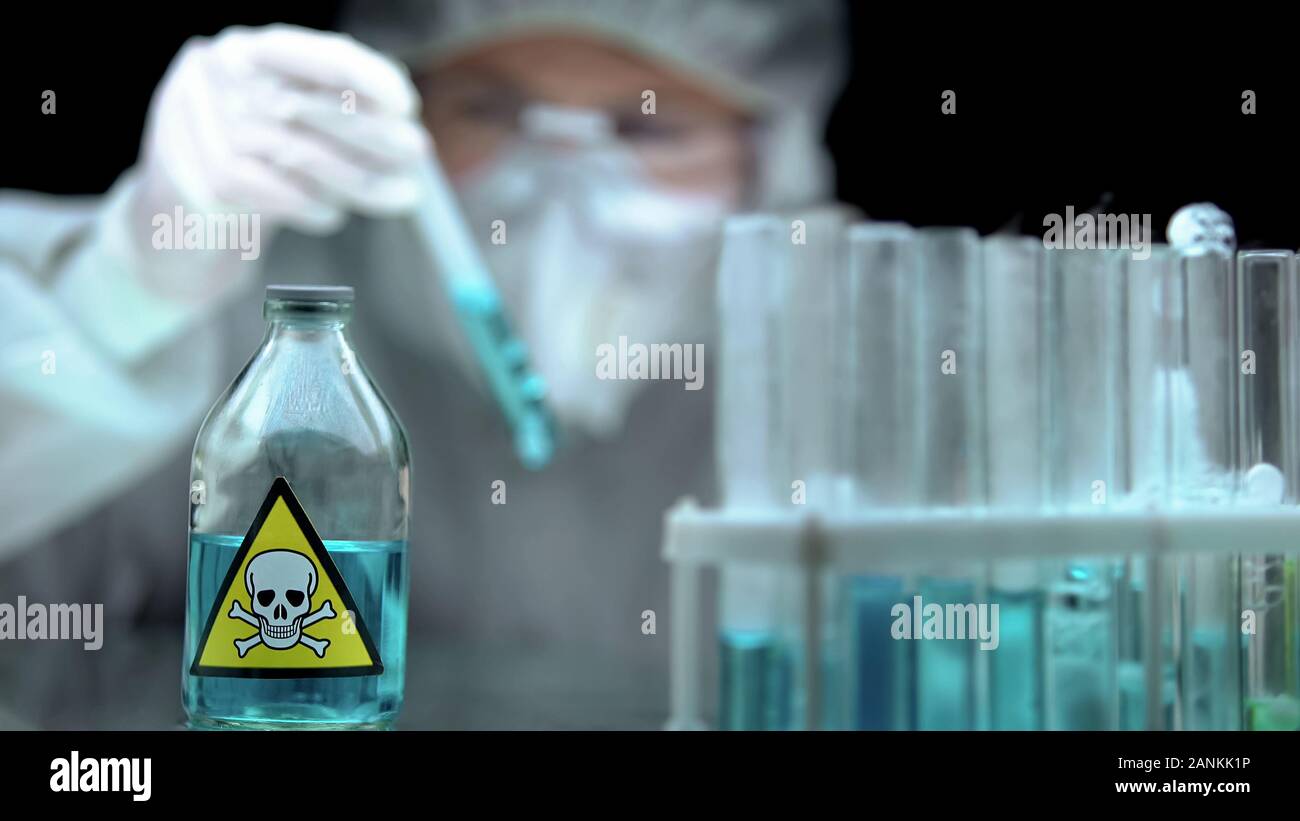Laboratory scientist analyzing blue poisonous liquid, forbidden ...