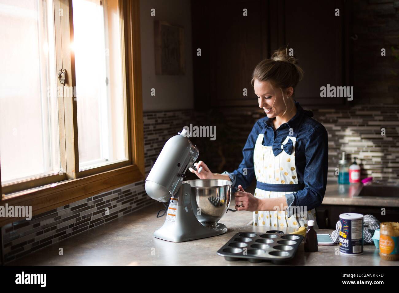 A young woman adding ingredients to her mixer Stock Photo - Alamy