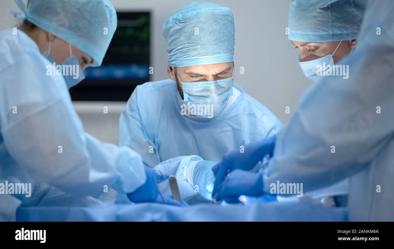 Nervous surgeons performing operation in hospital with modern equipment ...