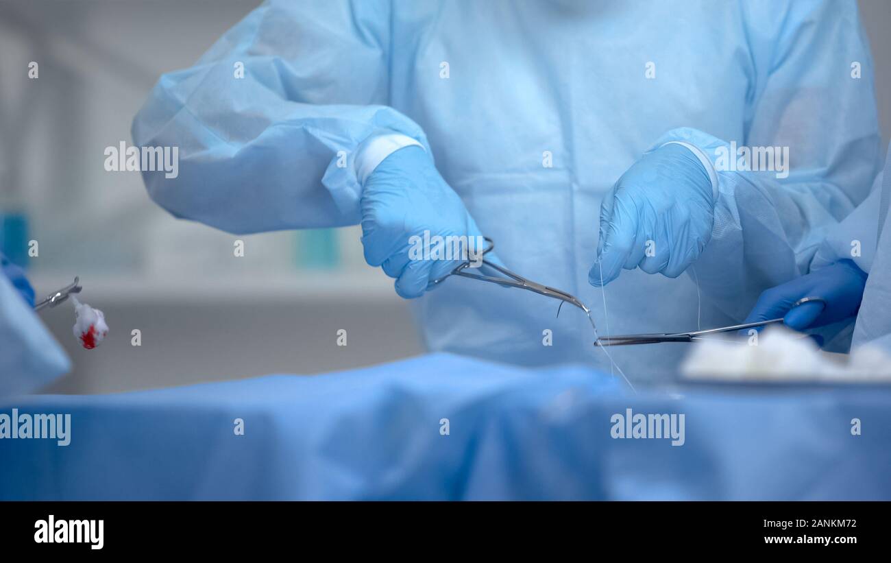 Professional surgeons sewing patient after hospital operation ...