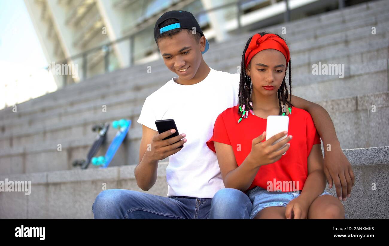 Gadget addicted teenagers playing smartphones ignoring each other ...