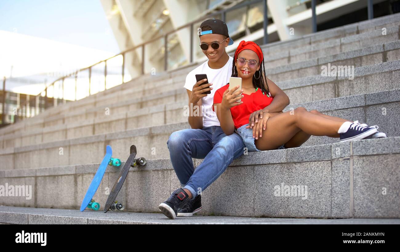 Modern teenagers laughing scrolling social networks on smartphone ...