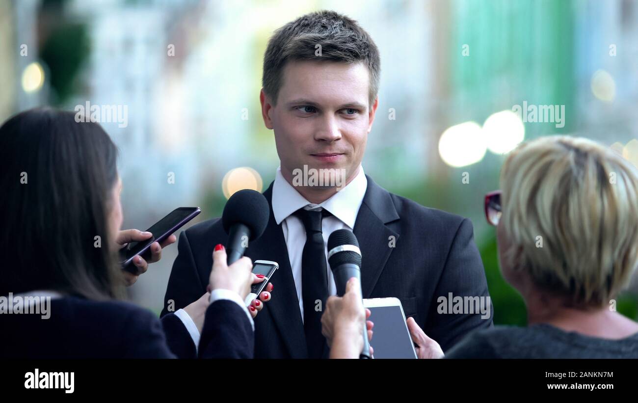 Smiling male millionaire giving interview on press conference, public ...
