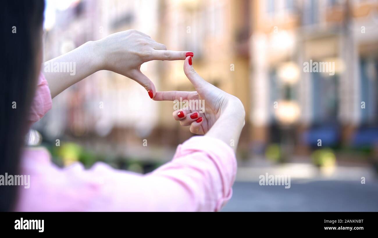 Close-up of womans hands making frame gesture on street, photography ...