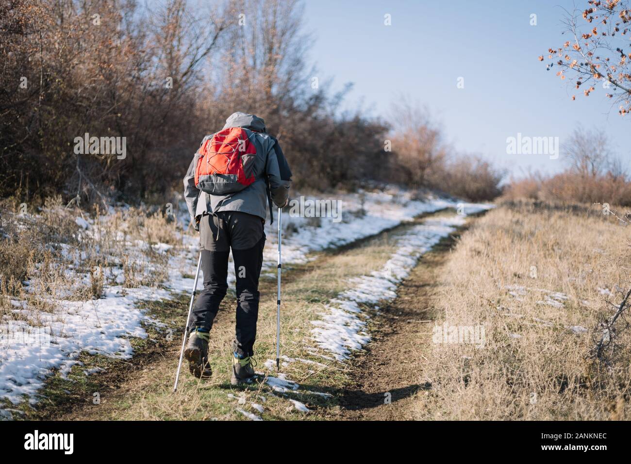 Back of man wearing backpack climbing mountain Stock Photo - Alamy