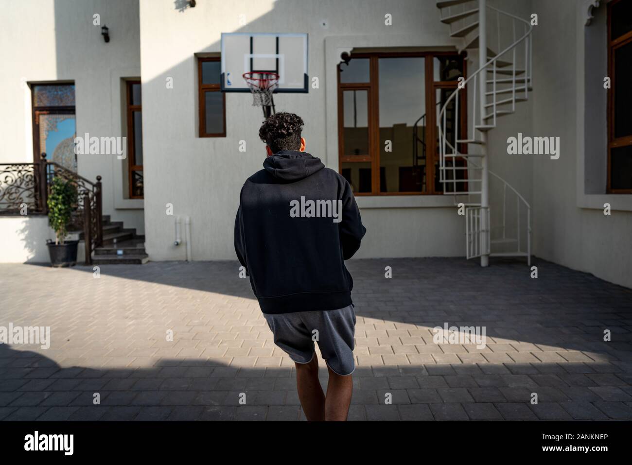 Young man playing basketball outdoors in the backyard | shooting a ball ...