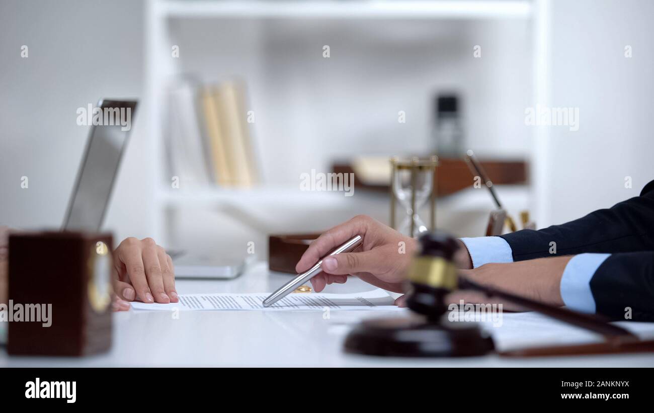 Attorney showing woman where to sign divorce document, legal ...