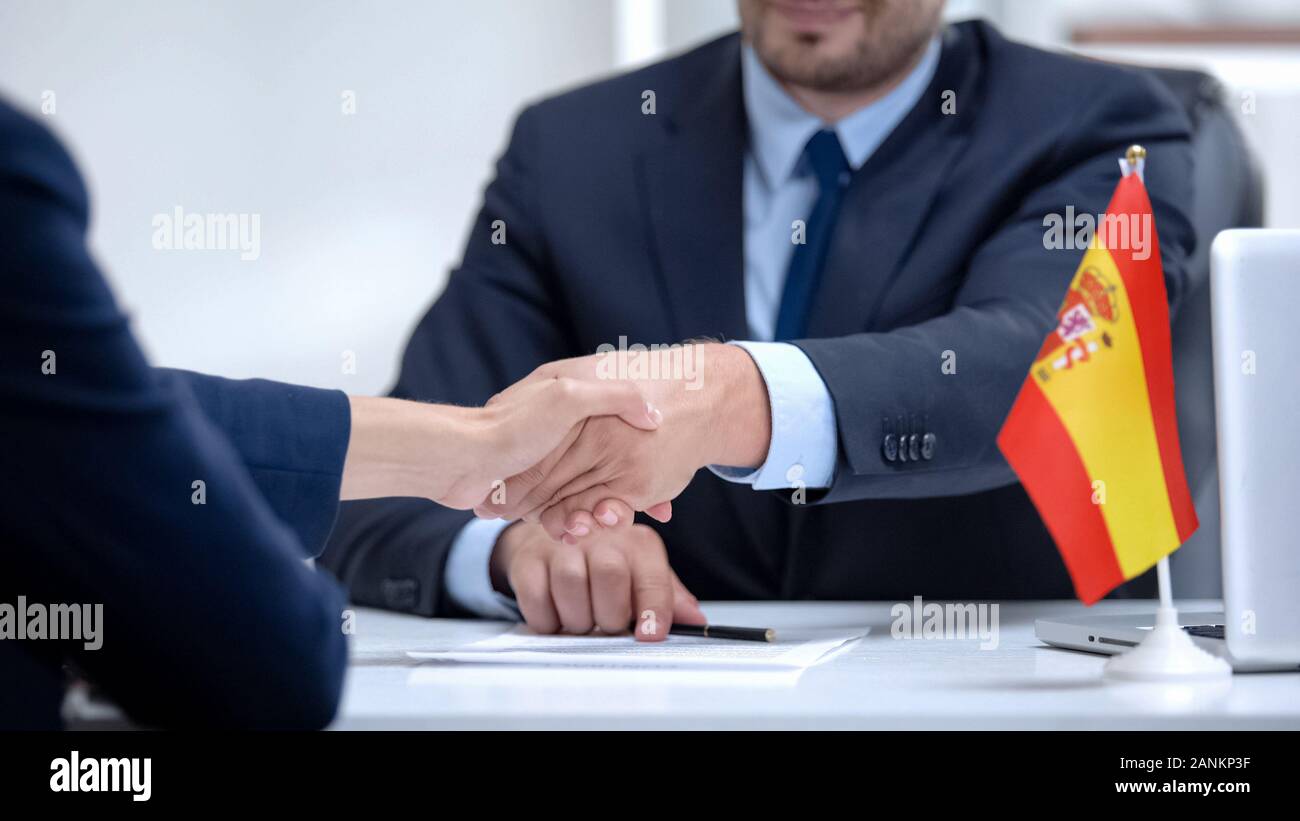 Spanish boss signing employment contract with immigrant employee ...