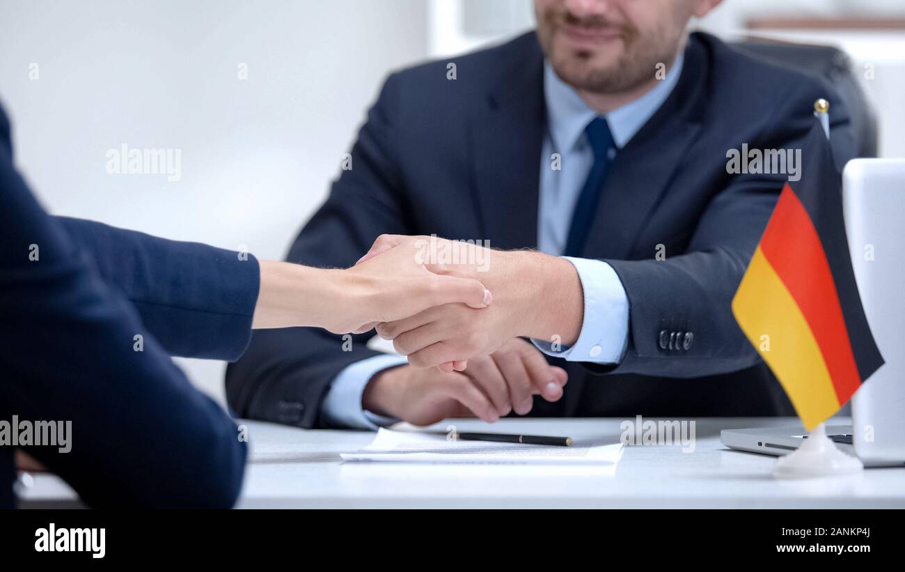 German boss signing employment contract with immigrant employee ...