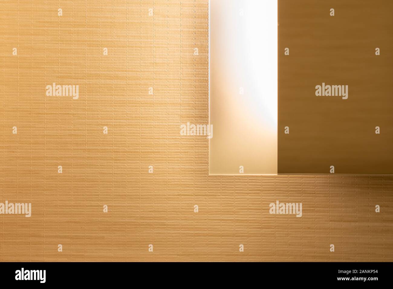 Textured wall background with a modern light fixture warm glow and ...