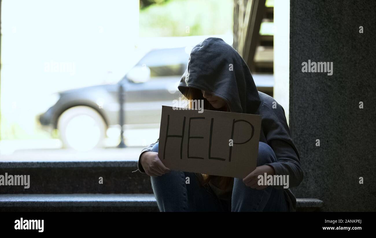 Teenage girl showing help sign sitting on stairs, lost in life, needs ...
