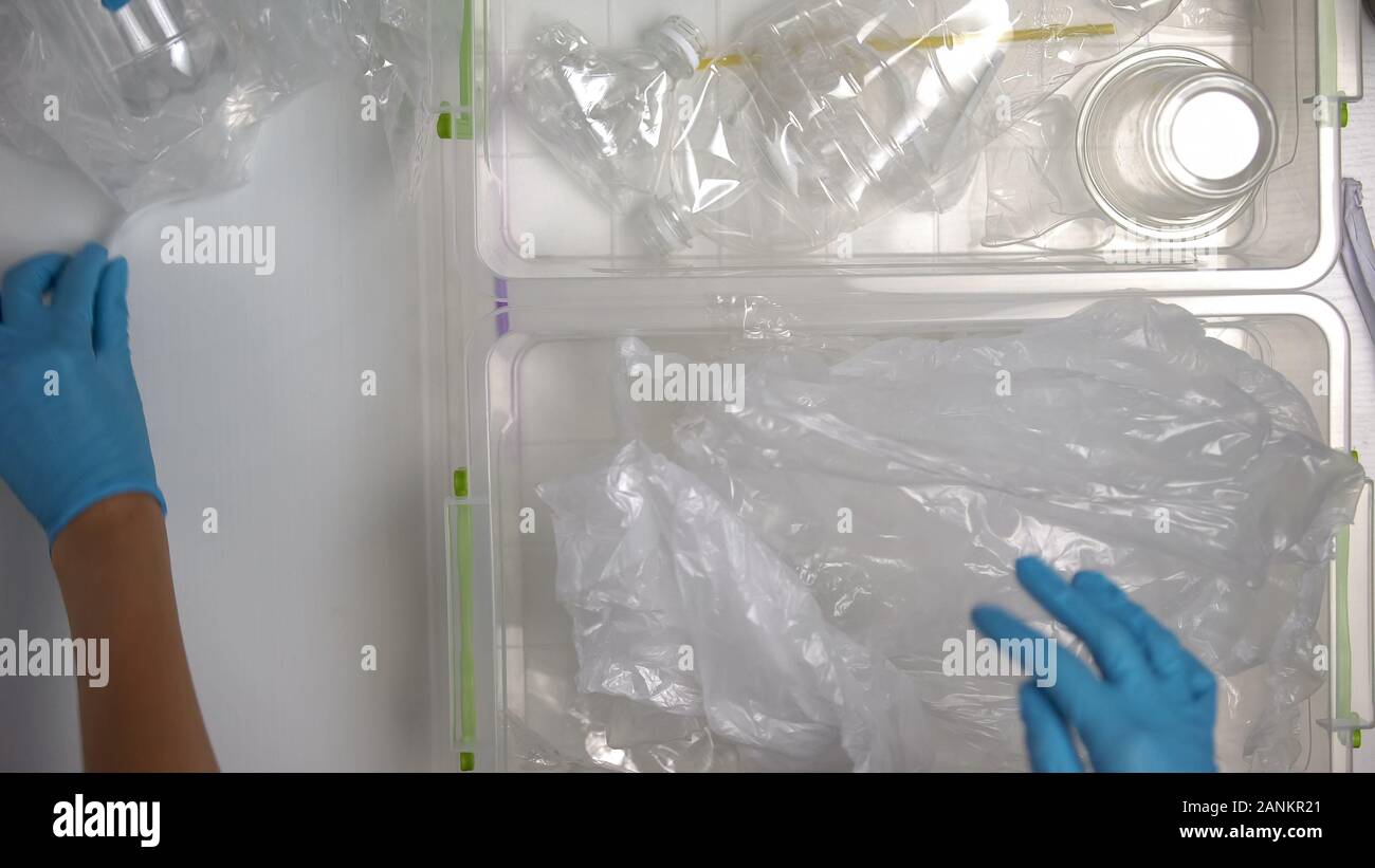 Volunteer hands sorting plastic waste on line at plant, reusable ...