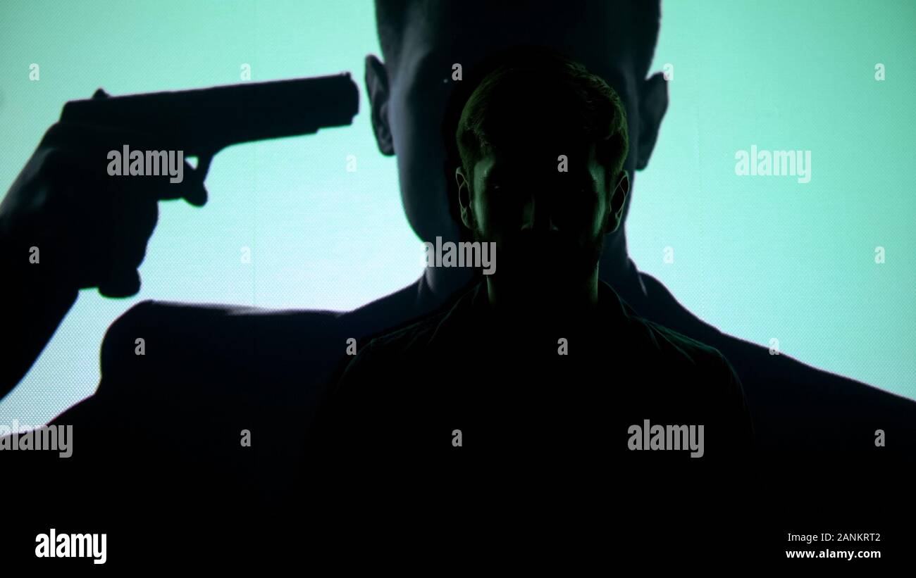 Depressed man thinking about suicide, gun near silhouette temple on ...