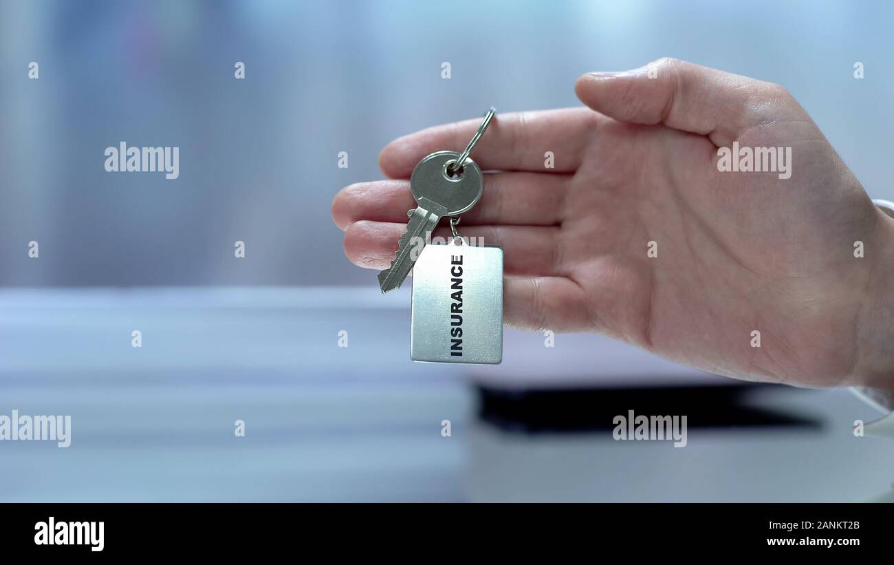 Insurance word written on keychain male hand showing to camera, life ...