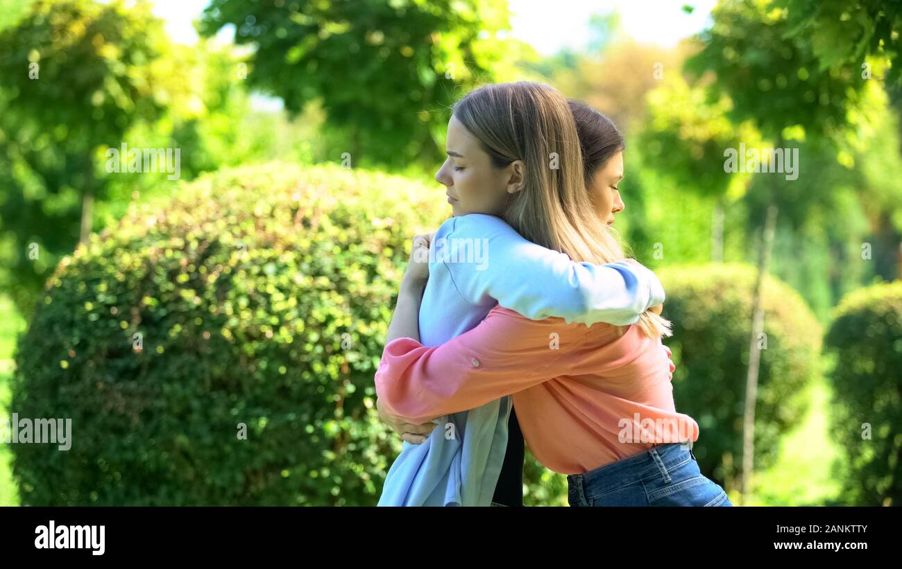 Two women hugging outdoor saying good-bye, friendship trusting ...