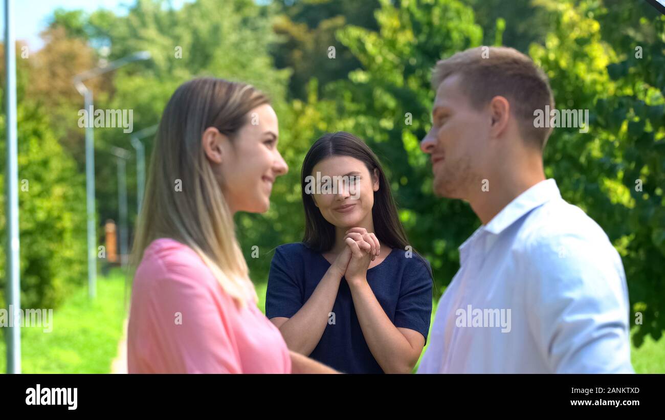 Happy woman looking at female friend smiling boyfriend, love affection ...