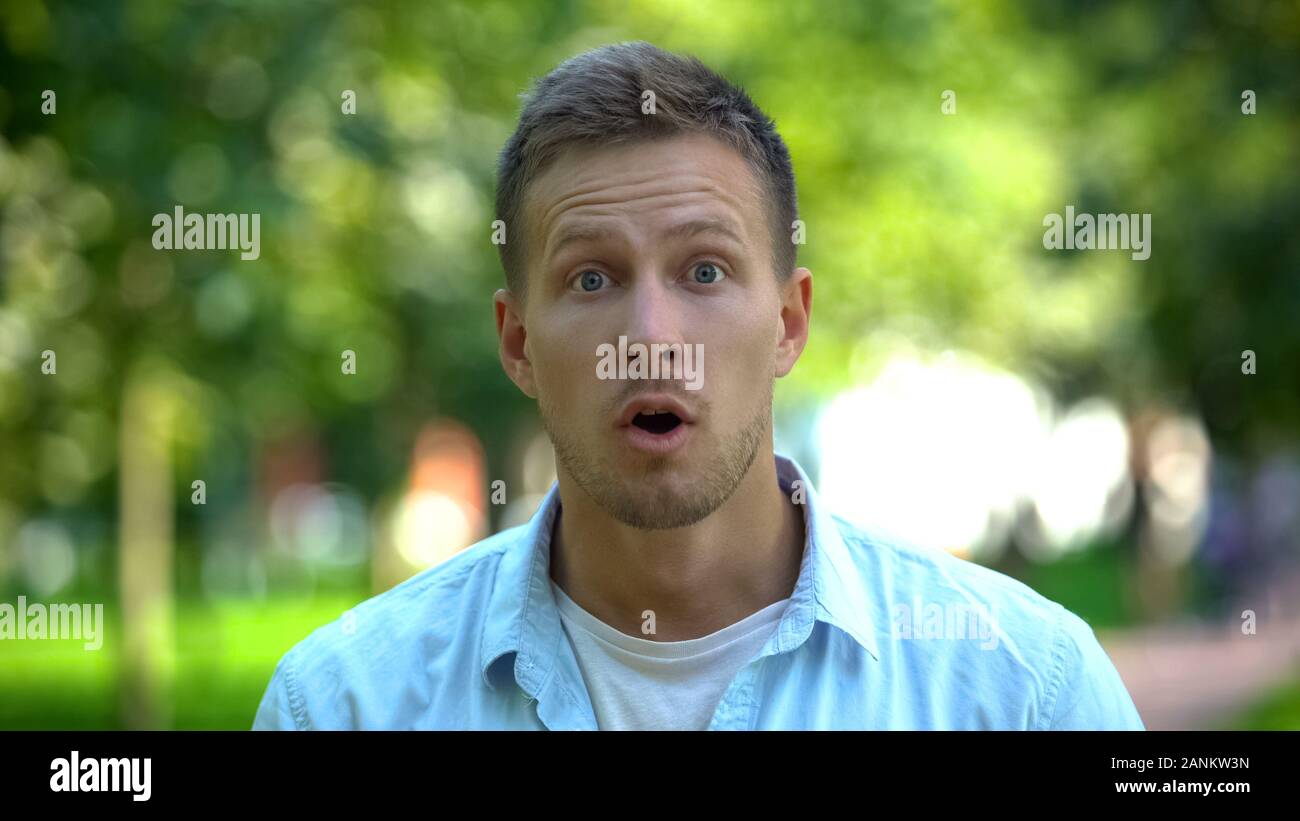 Shocked young male looking at camera, surprise reaction, good news ...