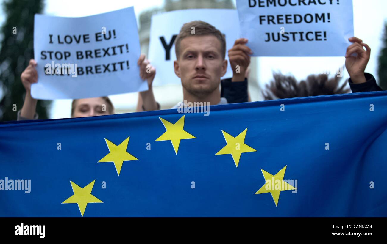 Young man holds European Union flag, activists with freedom slogans on ...