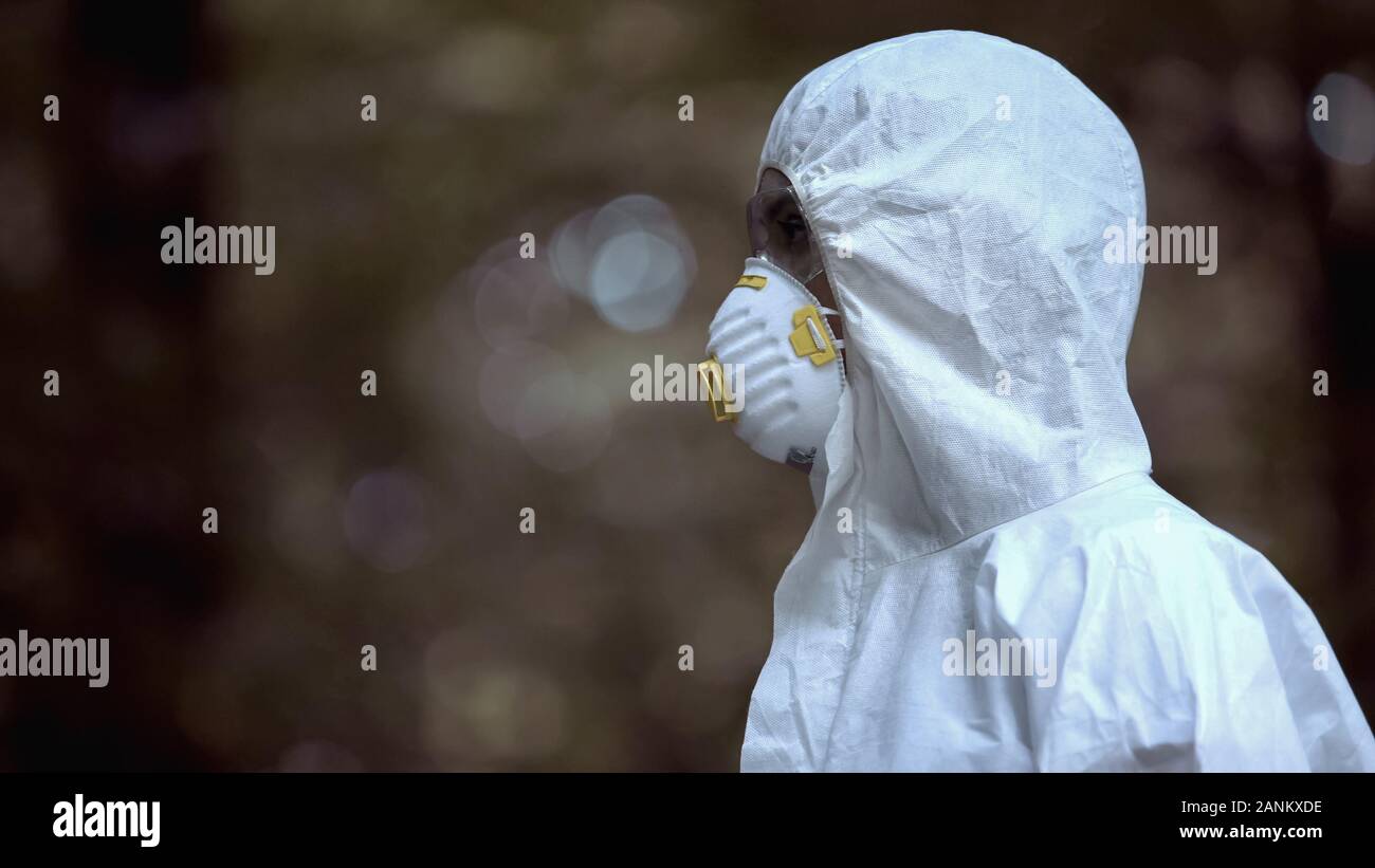 Biochemist wearing protective uniform in abandoned forest, statistic ...