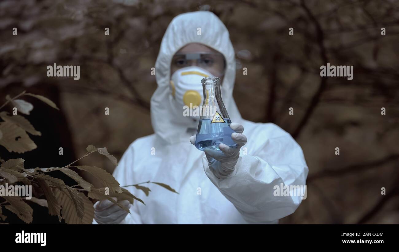 Female scientist showing test tube radioactive water marked poison ...