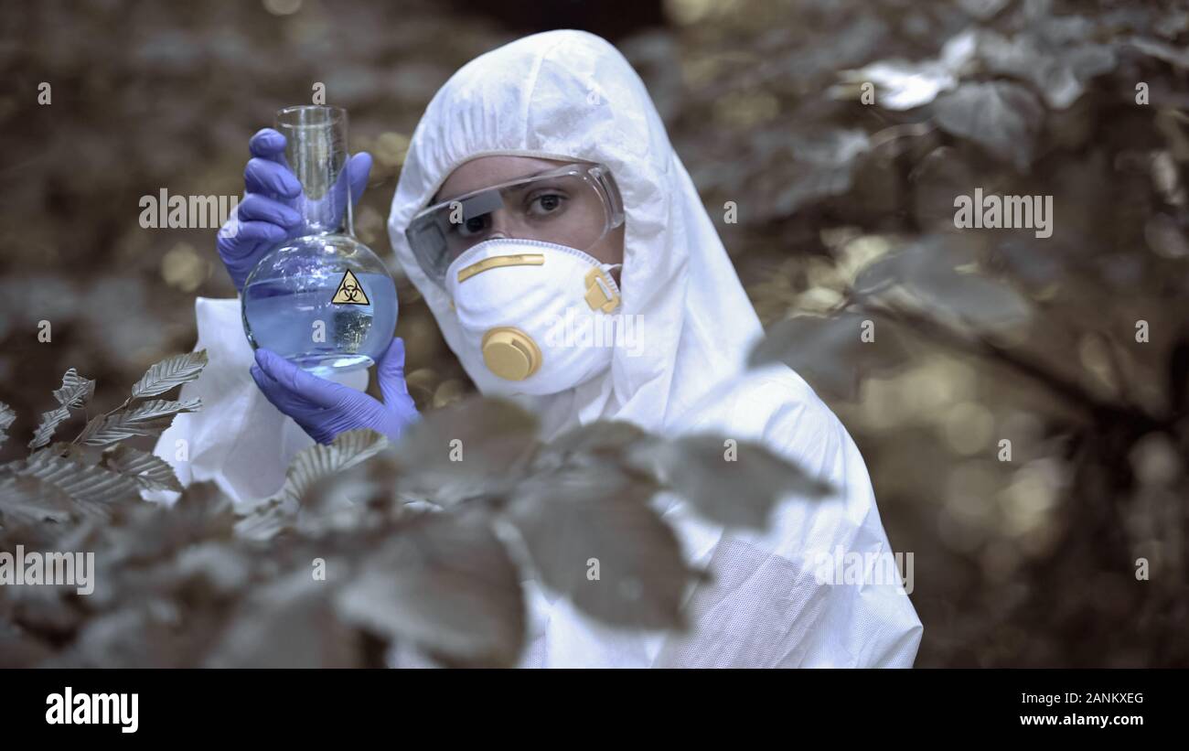 Lab worker holding biohazard test tube, dangerous virus, global threat ...