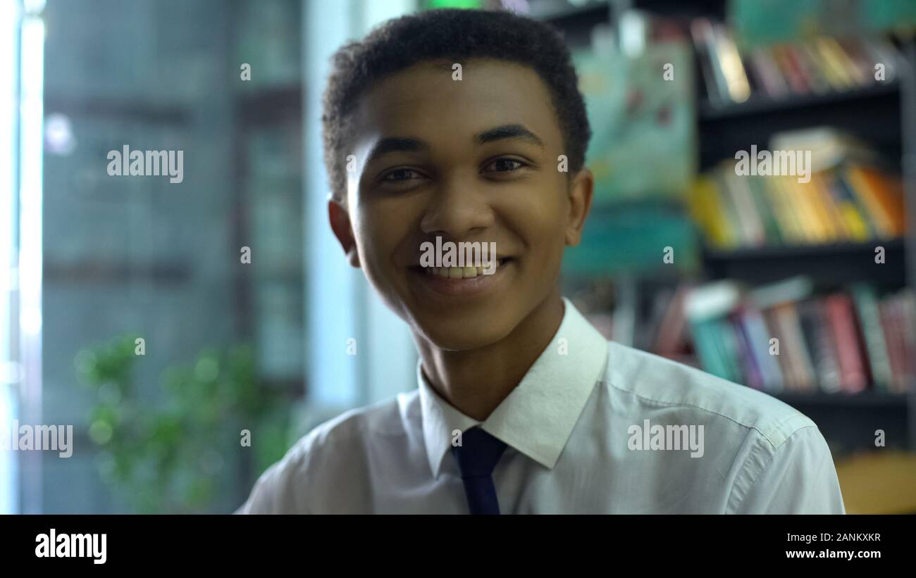 Happy black male student in uniform sincerely smiling on cam pleased ...