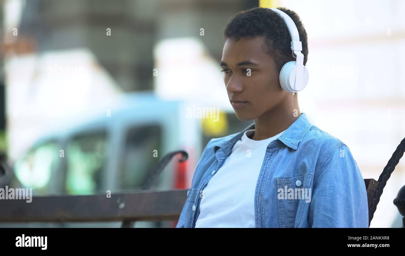 Sad mixed-race boy listening to favorite romantic song, yearning on ...