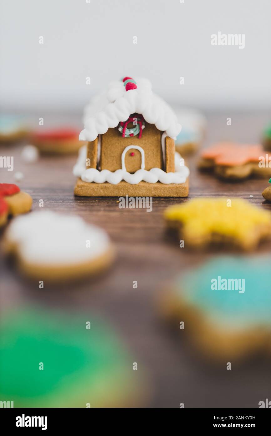 festive gingerbread house and cookies in different colors and shapes, a ...