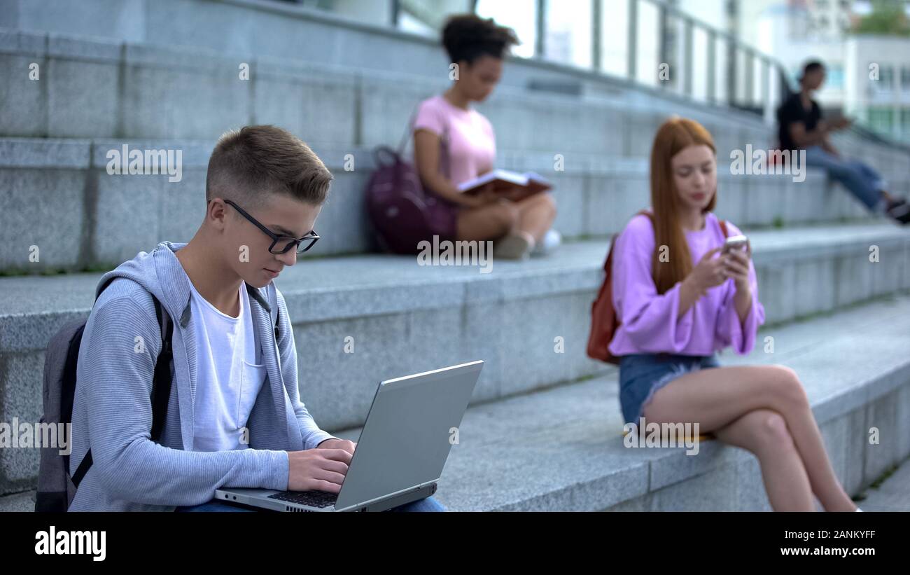 Genius university student in eyeglasses working laptop outdoors, IT job ...