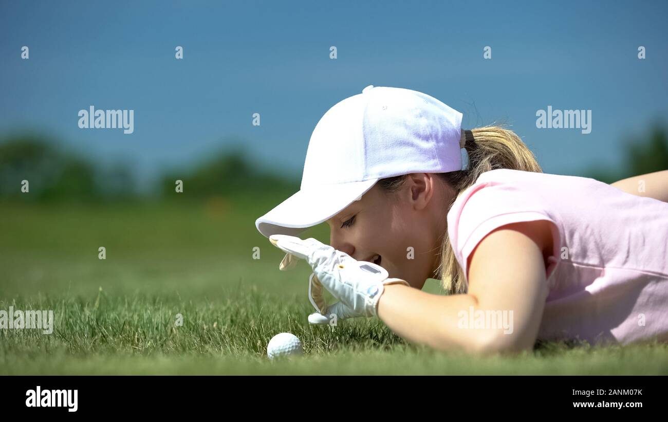 Cunning woman hitting golf ball in hole with finger, having fun during ...