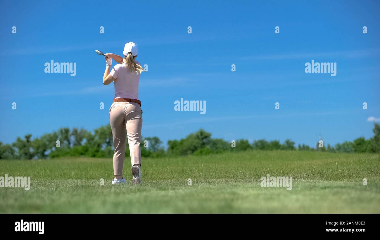 Skilled female golfer hitting ball in backswing position, training and ...