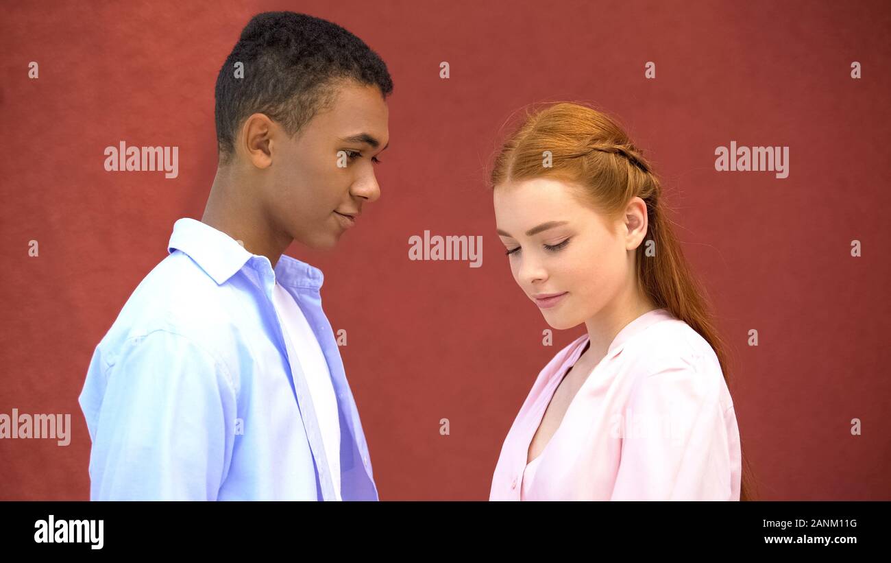 Boy looking at shy pretty girlfriend with love, first tender ...