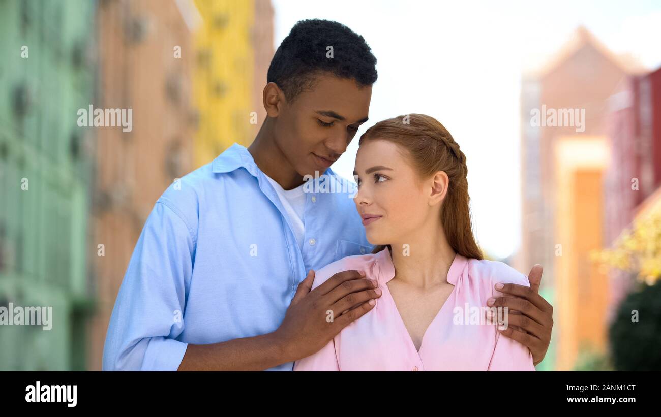 Caring boyfriend hugging girlfriend by shoulders, teenager relationship ...