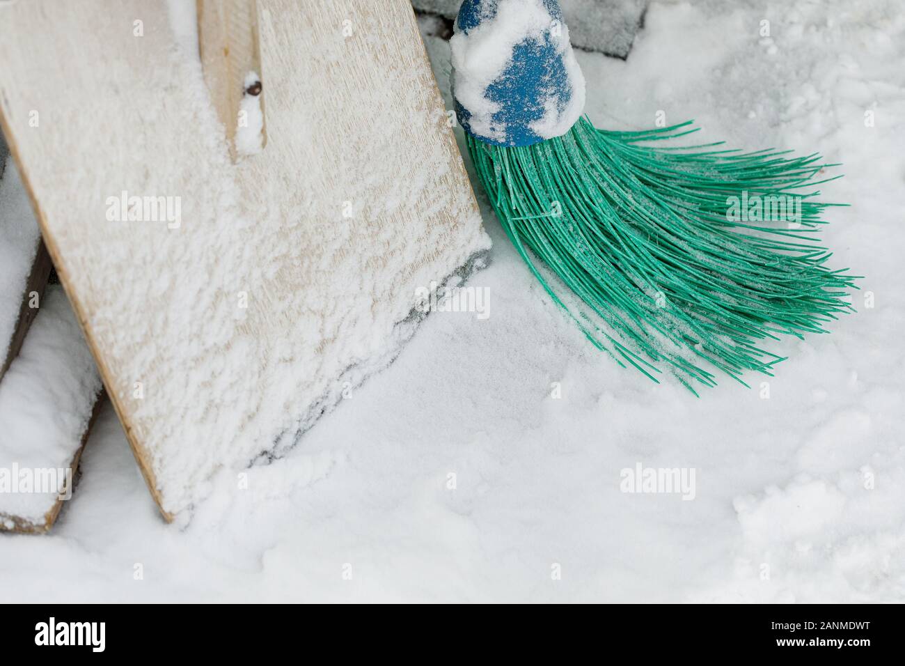 Broom and shovel in snow. Winter inventory for cleaning the territory ...