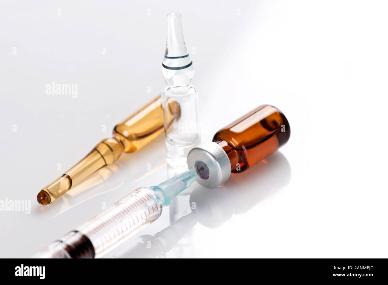Amber colored vial and amber and clear ampules with syringe on ...