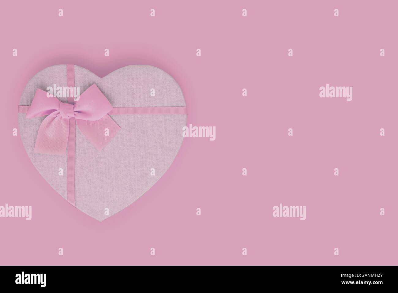 Light pink heart shaped gift box with ribbon bow on pink background ...