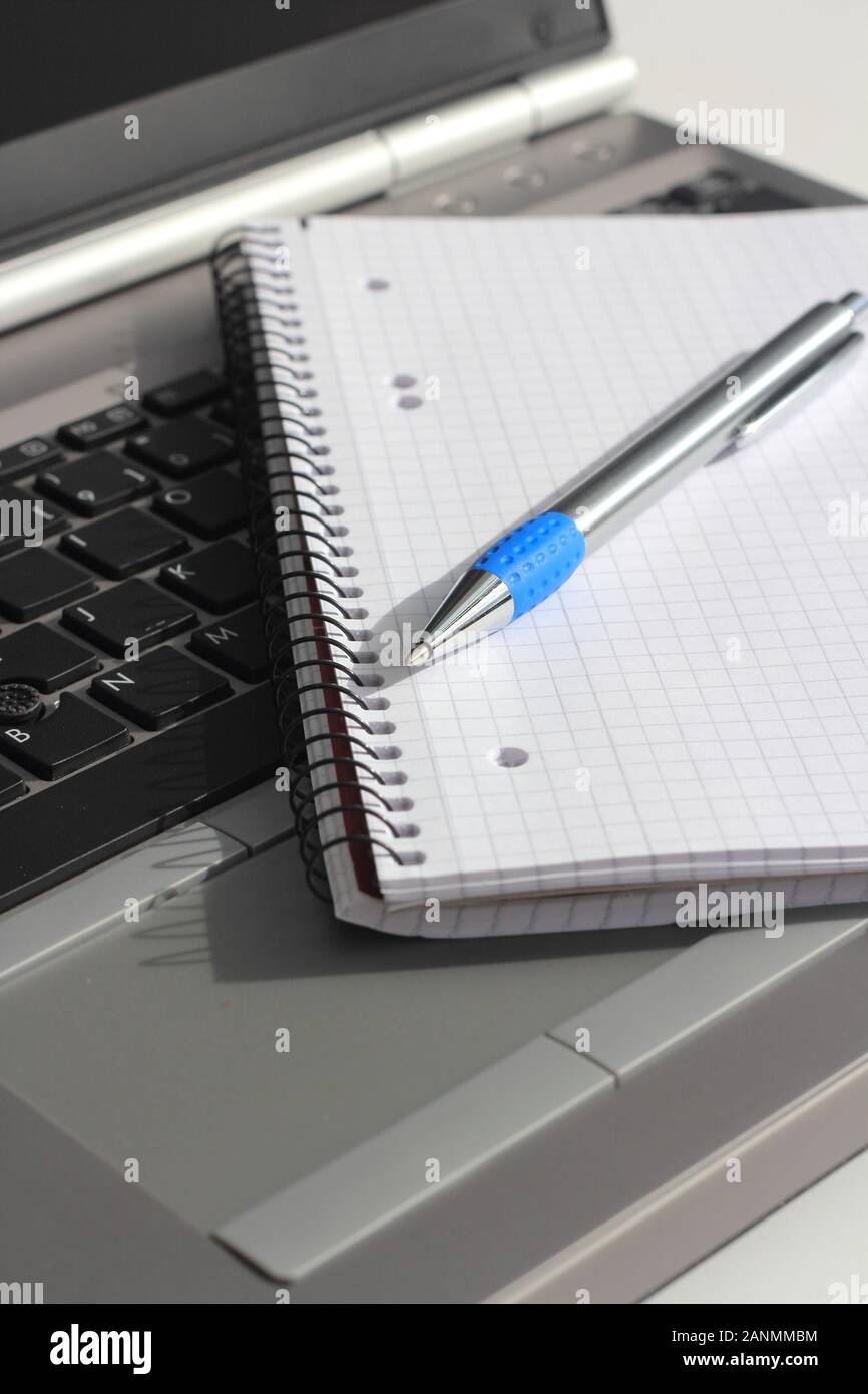 a laptop keyboard with a block and pen Stock Photo - Alamy