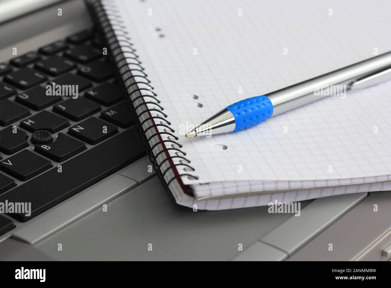 a laptop keyboard with a block and pen Stock Photo - Alamy