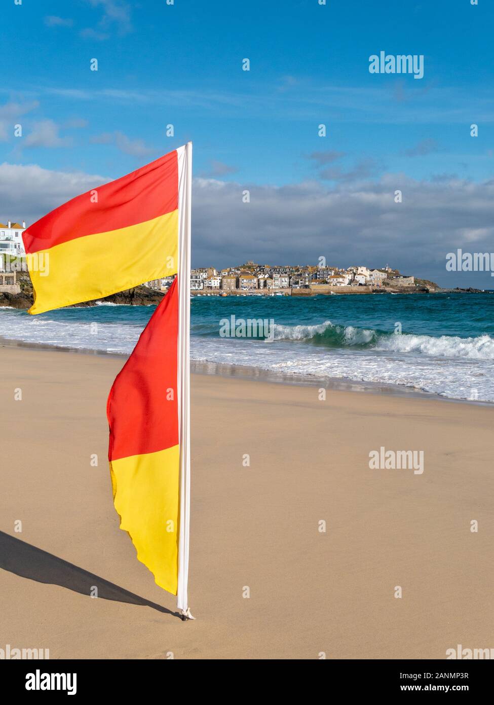 Lifeguard flags blowing in sea breeze marking safe swimming area ...