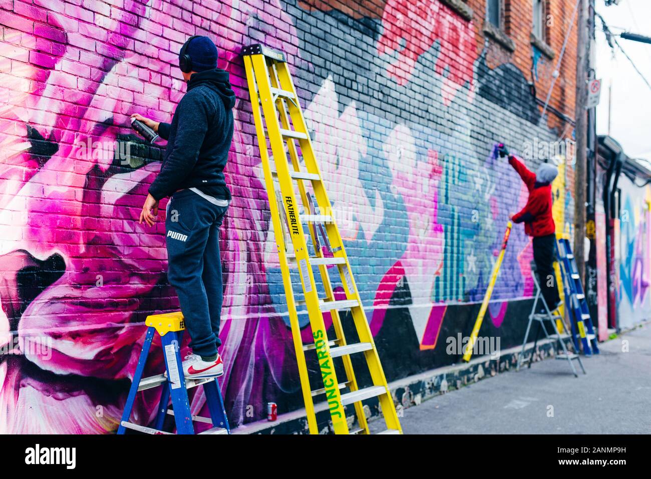 canada, toronto - december, 2019 Graffiti artist spraying the wall ...