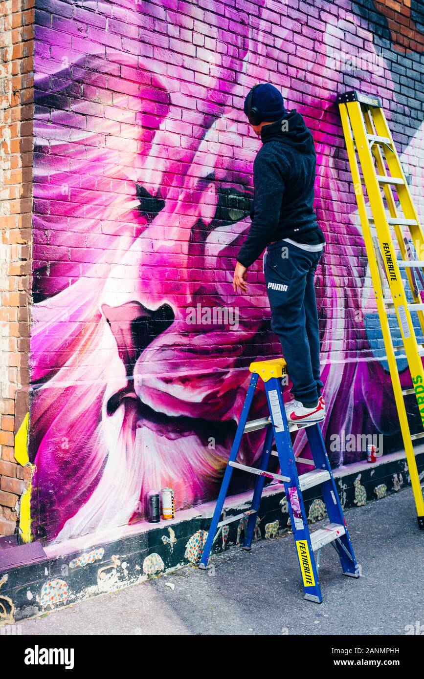 canada, toronto - december, 2019 Graffiti artist spraying the wall ...